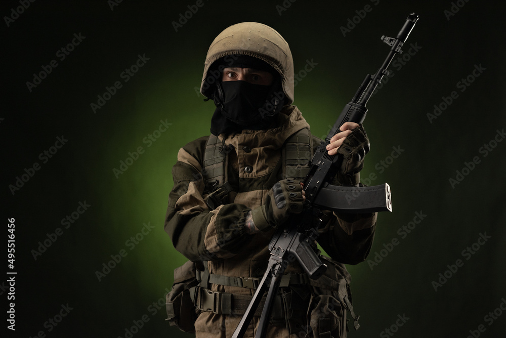 a Russian soldier in a helmet in military clothes with a Kalashnikov ...