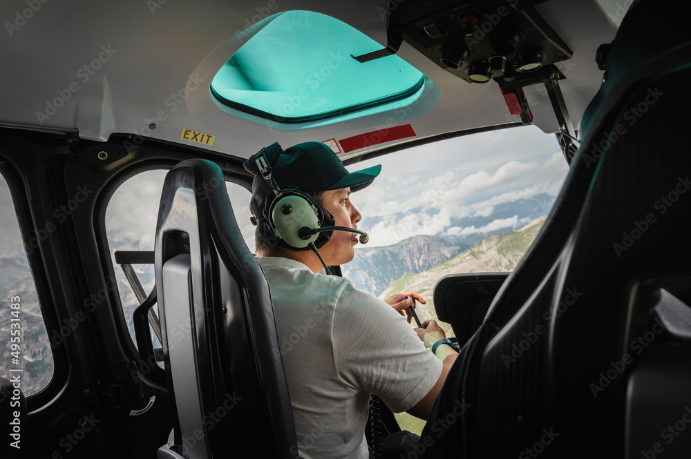 Man sitting in helicopter cabin while flying over Italian Alps Stock ...
