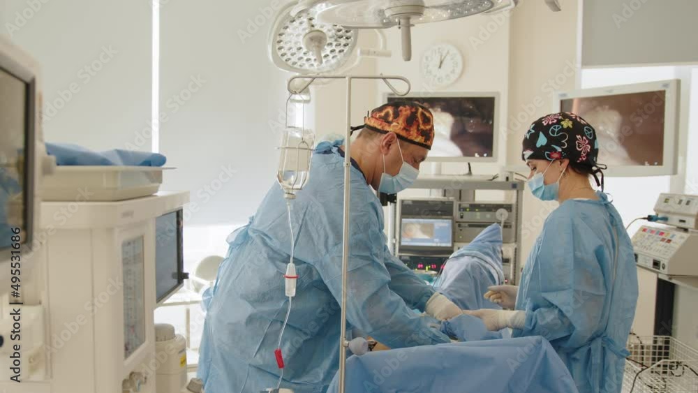 Surgeons team preforming operation in hospital operating theater, male ...