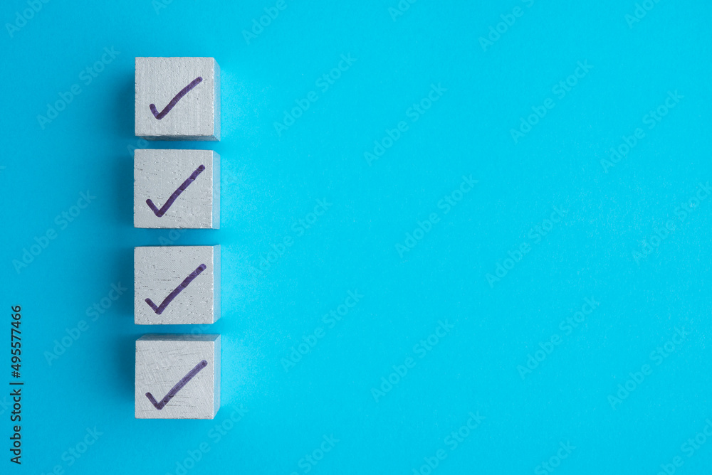 Check mark sign on white block checklist wooden with blue background ...
