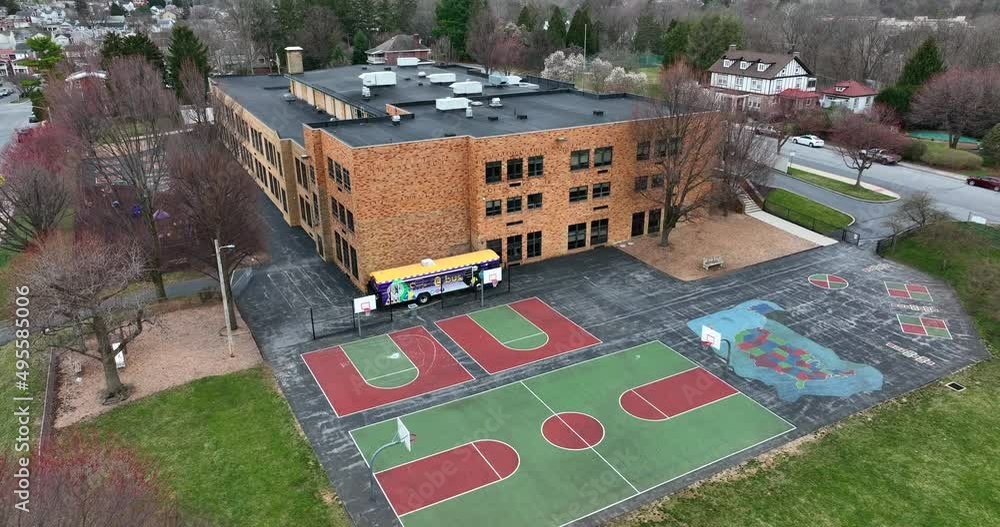 School building and playground for recess. Rising pullback aerial ...