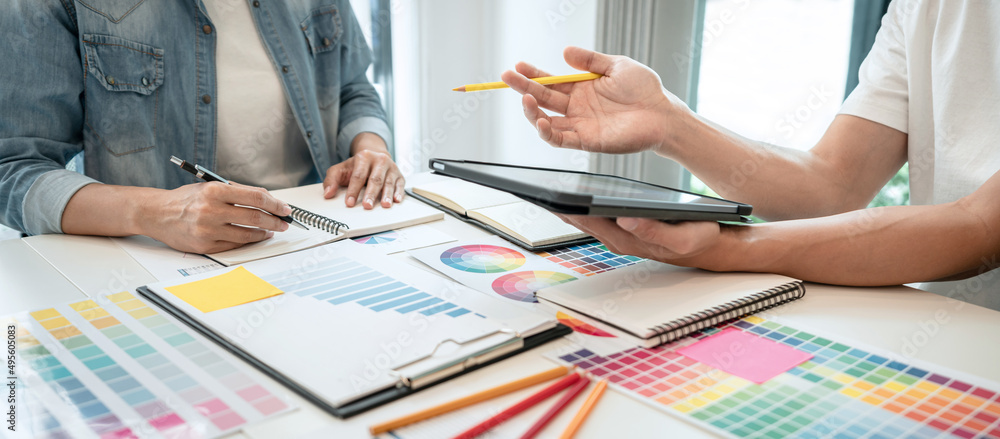 Two creative graphic designer working on color selection and drawing on ...