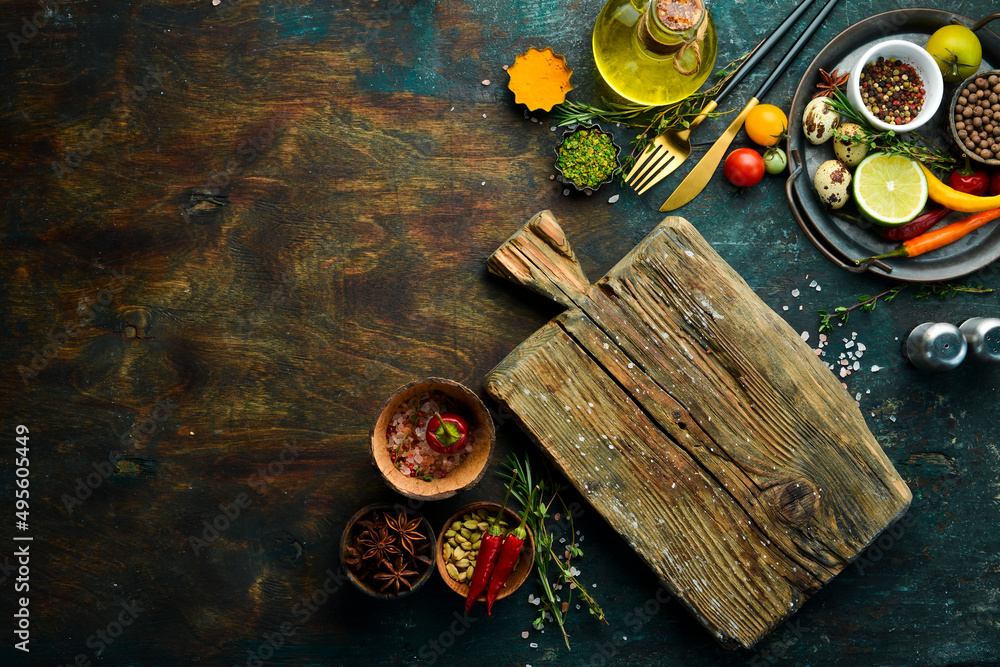 Wooden board on a black stone table with vegetables and spices. Food ...