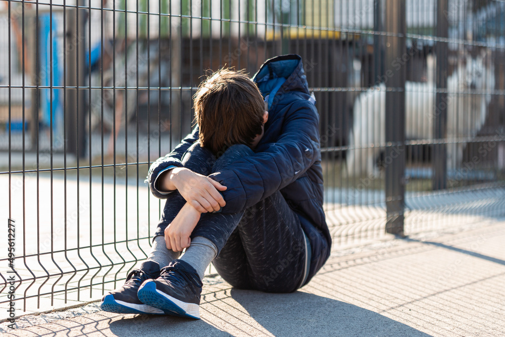 Sad boy sitting and crying on street. Negative emotion. Stock Photo ...