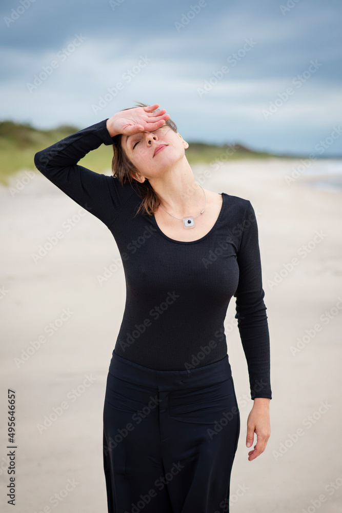 Relaxed woman on the beach in black danger Stock Photo | Adobe Stock