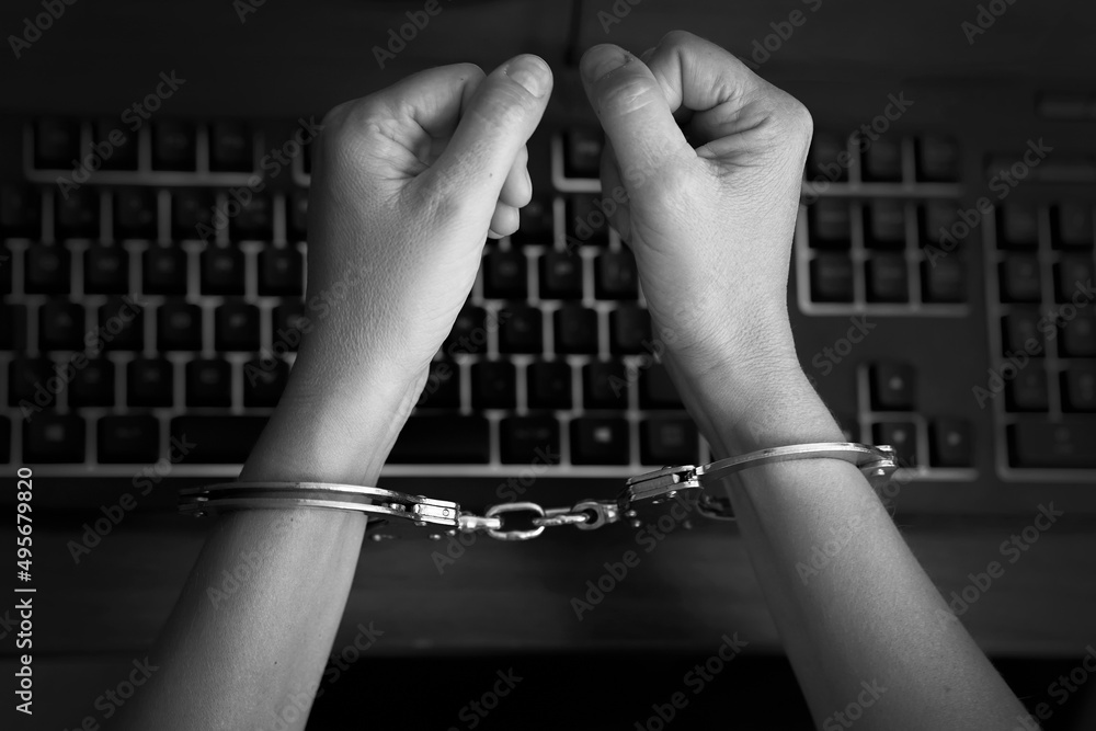 Hands of arrested woman hacker in handcuffed on compuer keyboard ...