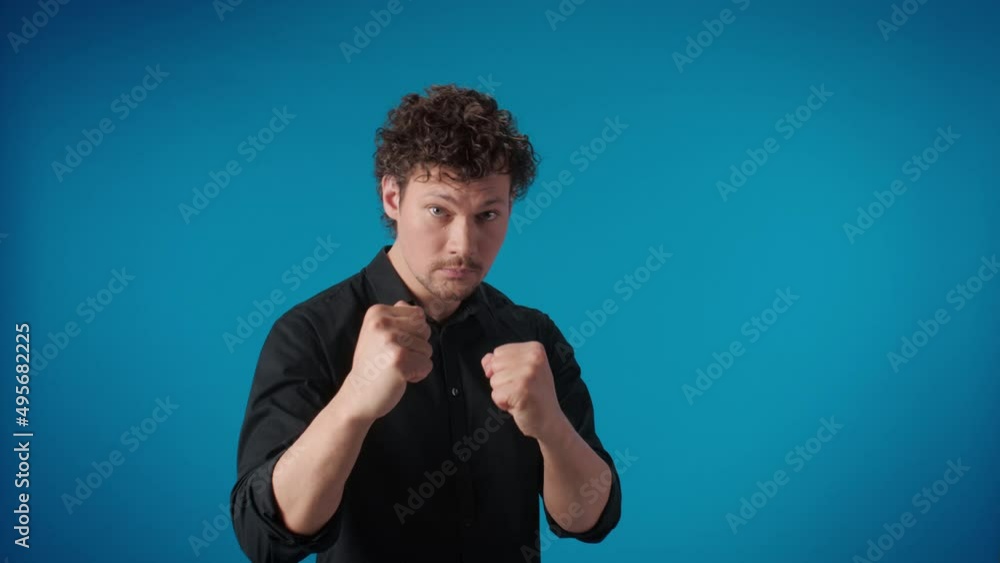 Portrait aggressive business man standing in fight combat posture ...