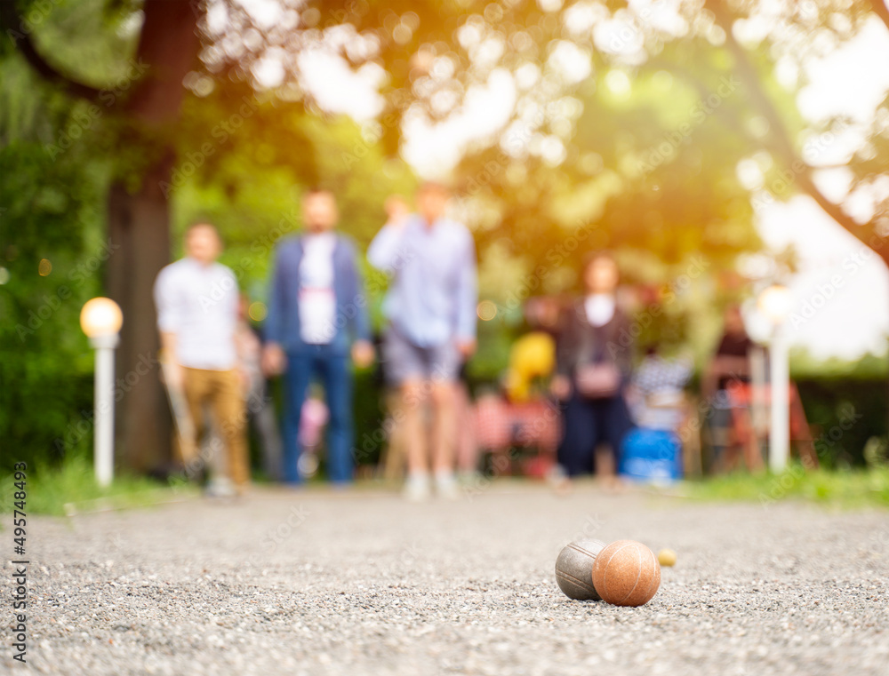 Group of people playing petangue outdoor game guy throw bocce ball in ...