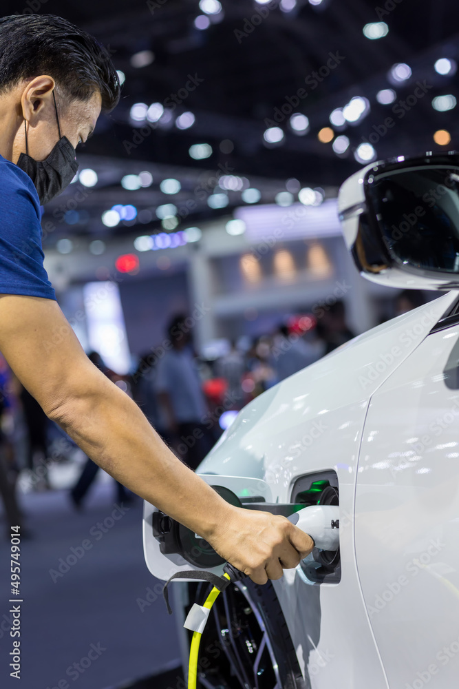 Hand holding Electric car charger. Electric Vehicle EV Charging station ...