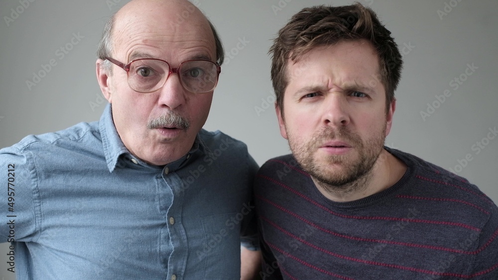 Surprised two men have scared expressions can not believe their eyes ...