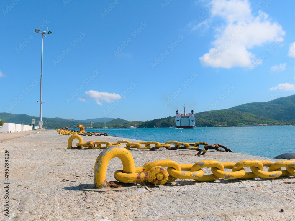 Yellow anchor chain harbor and metal spotlight with calm sea against ...