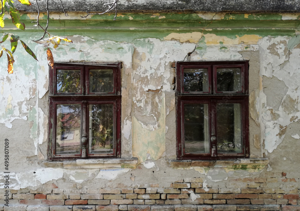 Old scattered wall with two glass windows and half brick wall in the ...