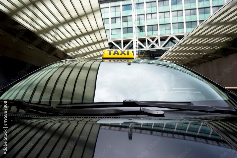 Taxi cab emerging from a garage underneath an office building. Stock ...