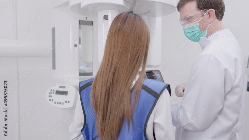 On a panoramic x-ray machine, the dentist aligns the bite of a woman ...