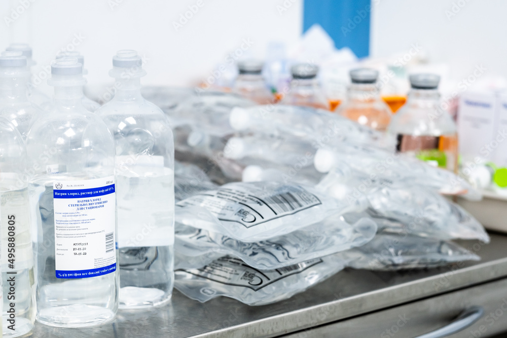 Saline bottles for intravenous infusion in a hospital on a metal table ...