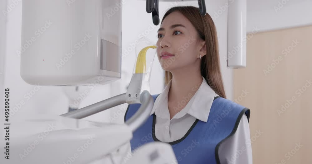 On a panoramic x-ray machine, the dentist aligns the bite of a woman ...