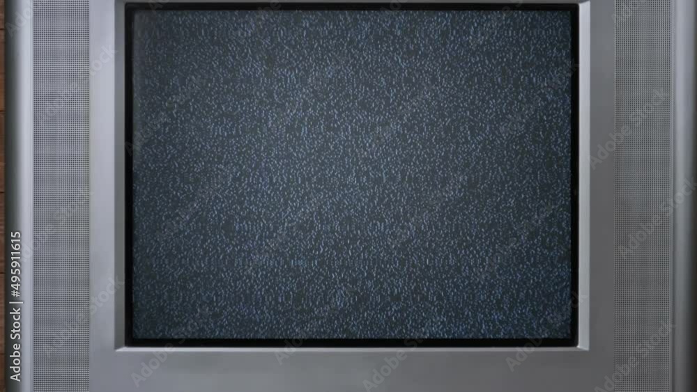 Static noise on the screen of an old CRT TV on wooden background. Zoom ...