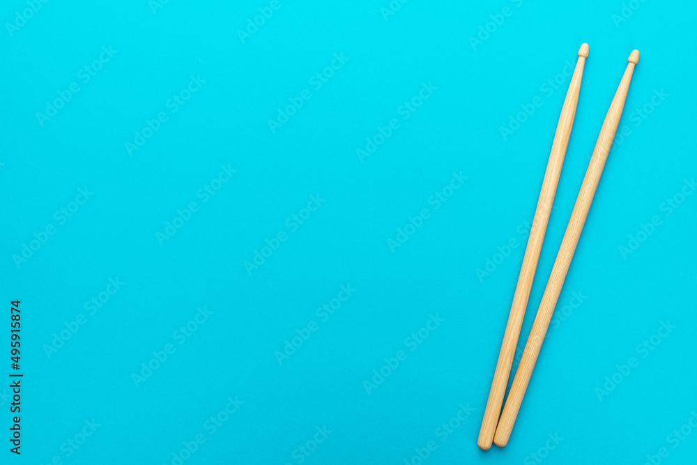 Minimalist photo of pair of wooden drumsticks on turquoise blue ...