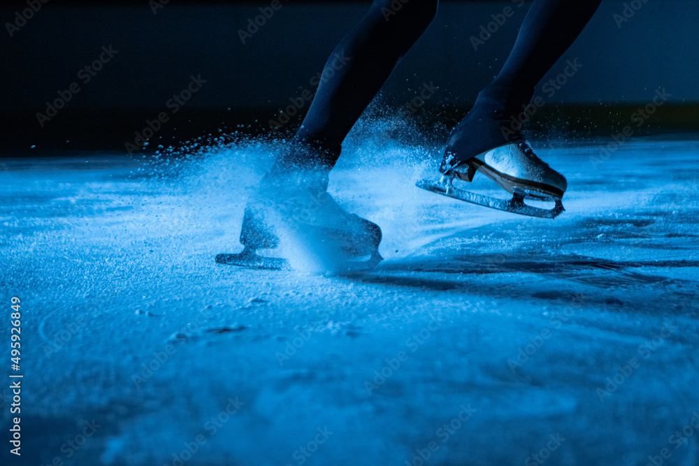 Detailed shot of women's legs in white figure skating skates on cold ...