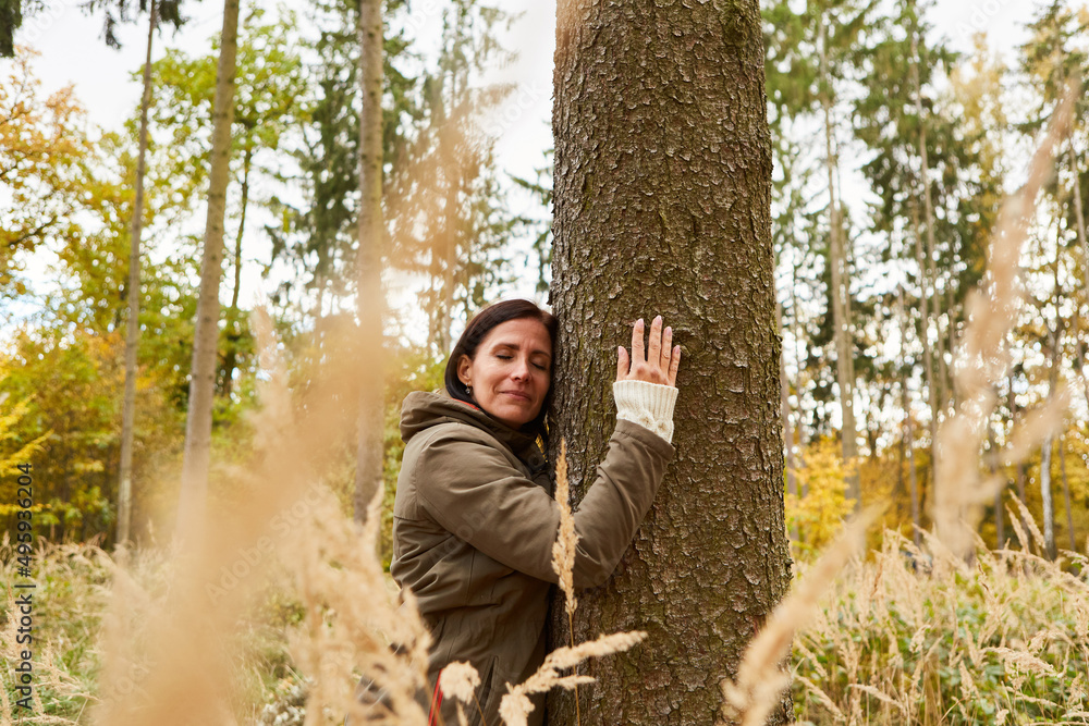 Woman forest bathing in nature hugs a tree Stock Photo | Adobe Stock