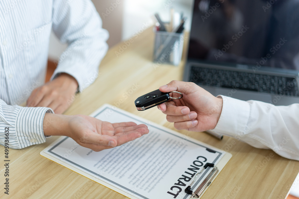 Insurance concept the car dealership giving a car key to his customer ...