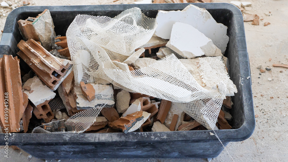 Workers putting construction waste into a plastic bucket Stock Photo ...