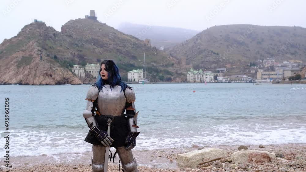 woman warrior in armor with sword and tears in eyes against backdrop of ...