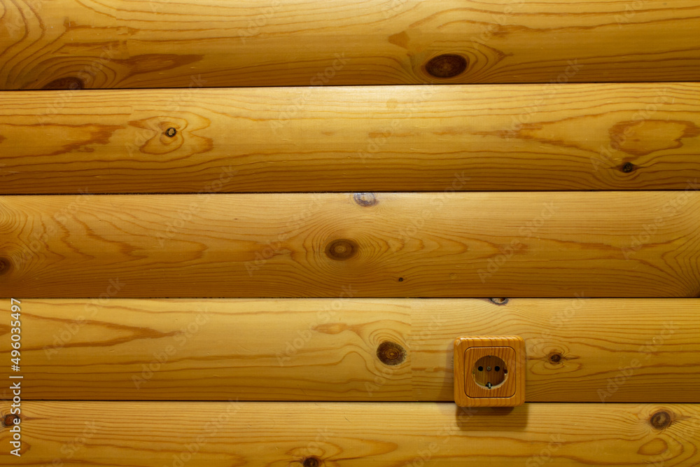 Log wall. Safety installation of an electrical outlet on the wall of a ...