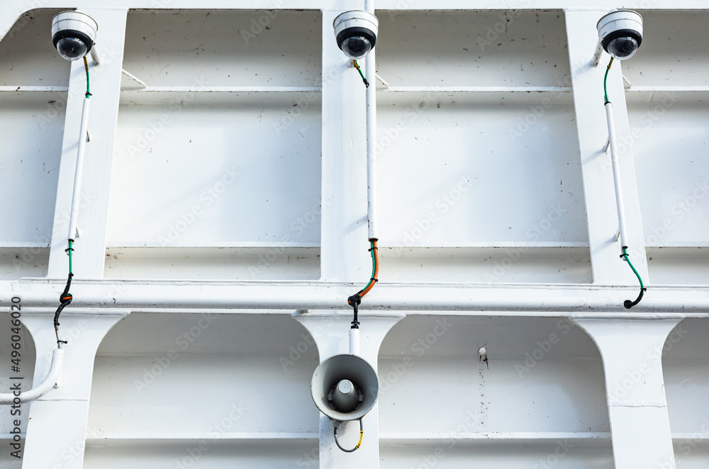 Surveillance cameras and a loudspeaker on the bulkhead of the ship's ...