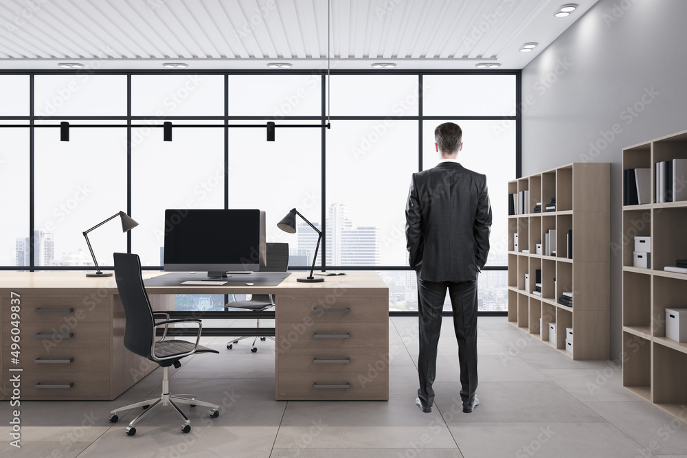 Young european man standing in modern wooden and concrete coworking ...