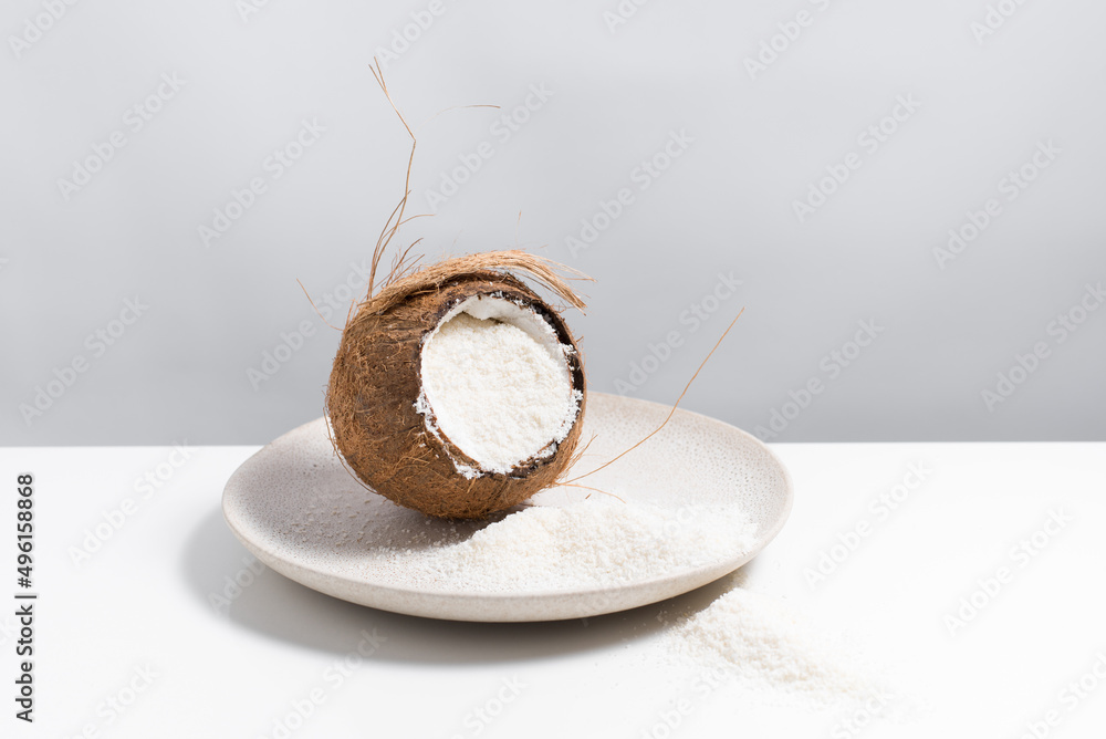 Coco abierto con carne de coco rallado sobre mesa blanca Stock Photo ...