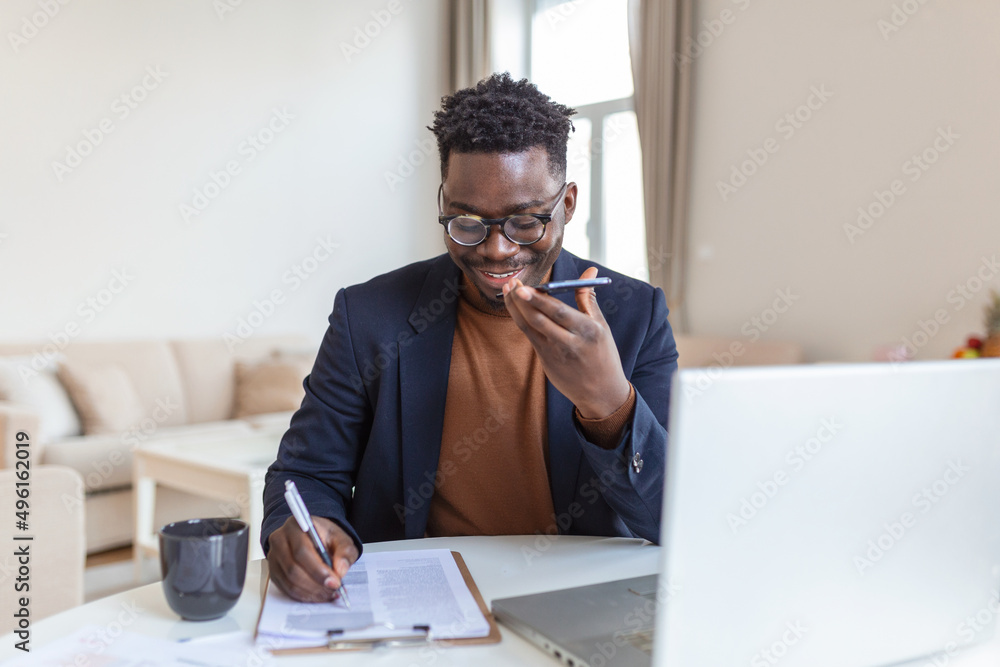 Arfican business man writing notes in notepad while talking by ...