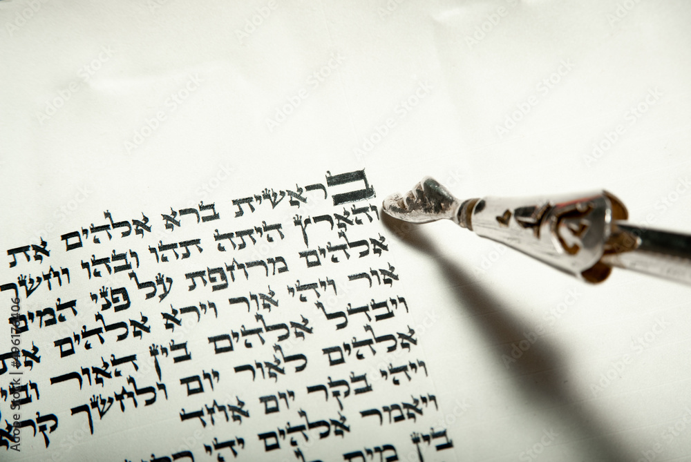 Photo A silver yad points to the opening verse of the Hebrew Bible ...