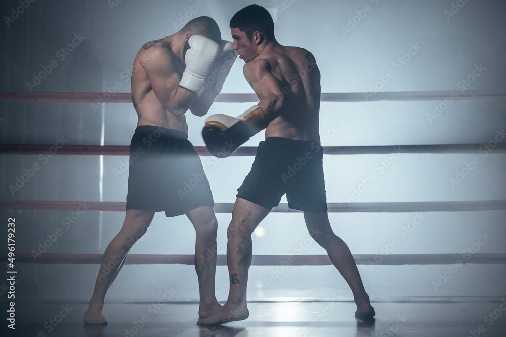 Two professional young muscular shirtless male boxers fighting in a ...