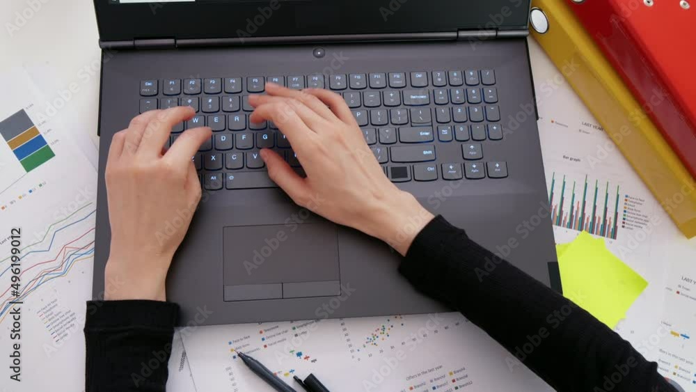 Female using laptop computer on office table background. Typing on ...