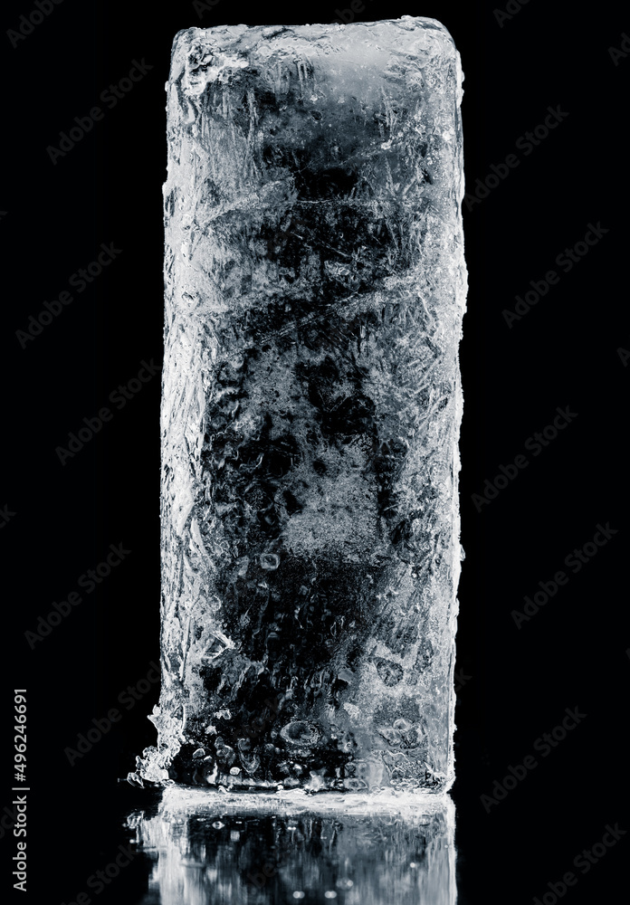 Solid textured natural ice block with cracks on a black reflective ...