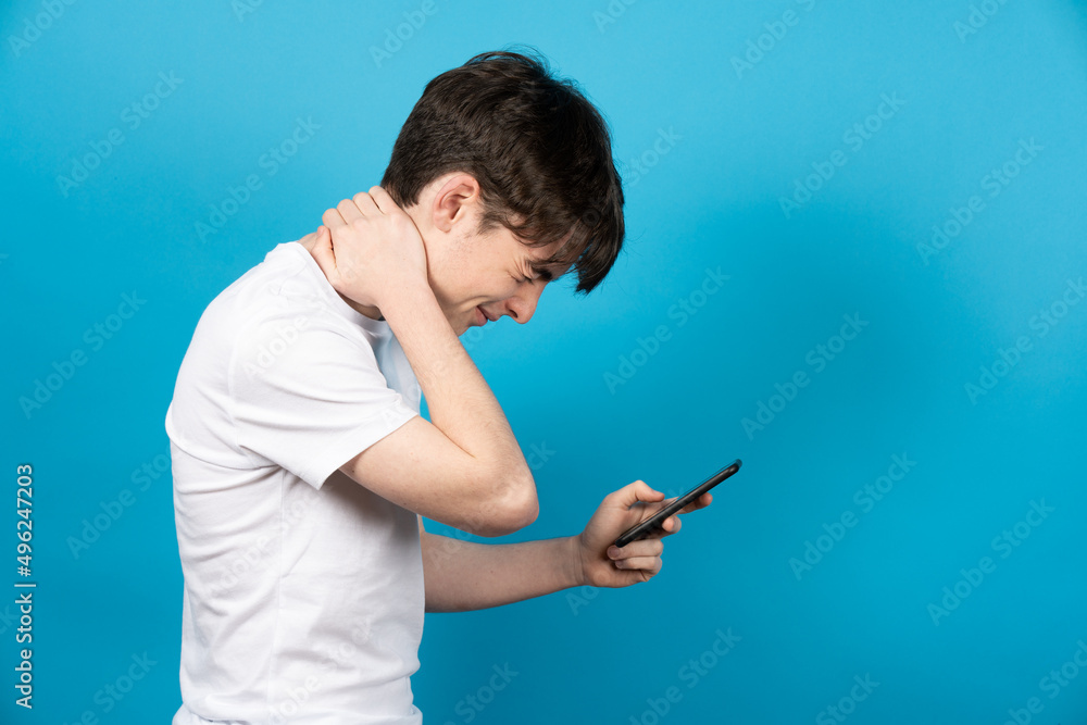 Teenager boy using phone with neck pain. Bad posture and digital ...