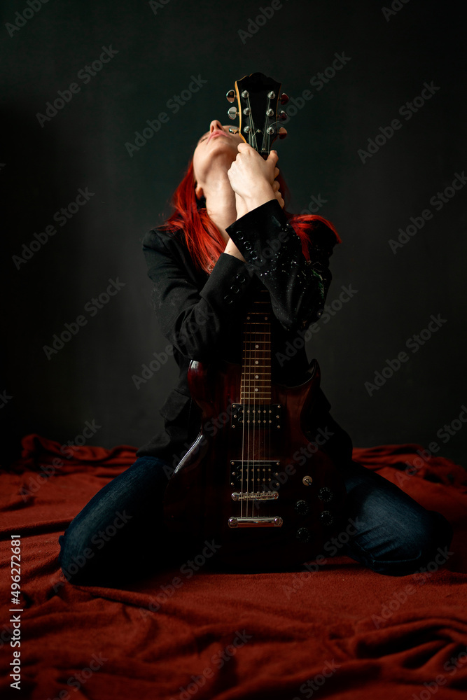 Sexy and brutal rocker punk or metal red-hair girl with an electric ...