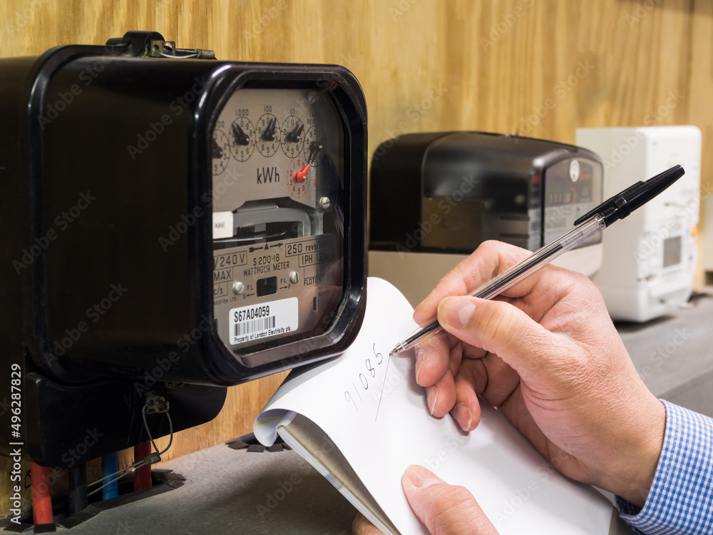 London, UK, April 1st 2022: Taking a meter reading, jotting or writing ...