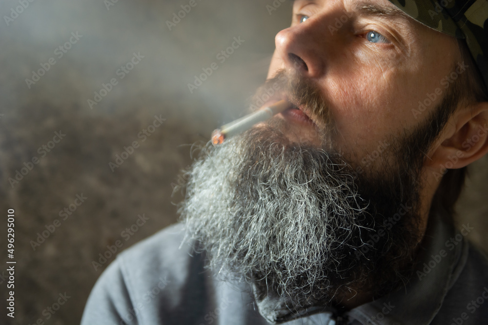 The man with the long beard is smoking a cigarette Stock Photo | Adobe ...