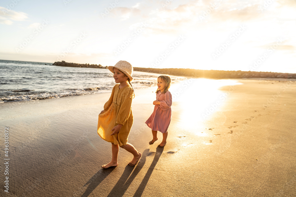 Kids playing on the beach. Little sisters walking at sea shore at ...