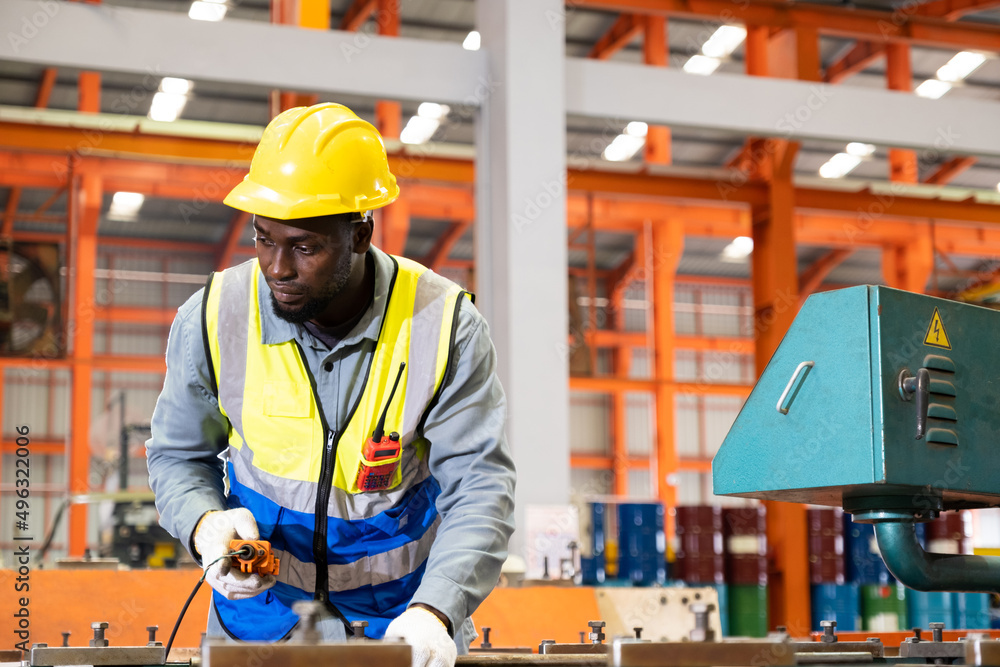 African men mechanical engineer, wearing safety equipment. While doing ...