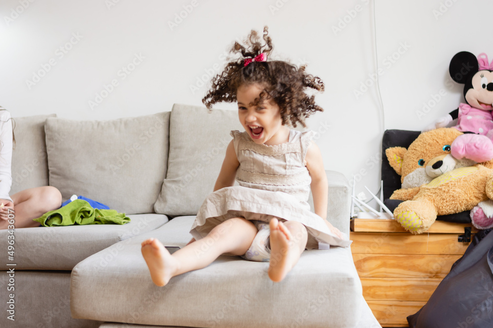 little baby girl in diapers happy screaming jumping on the living room ...