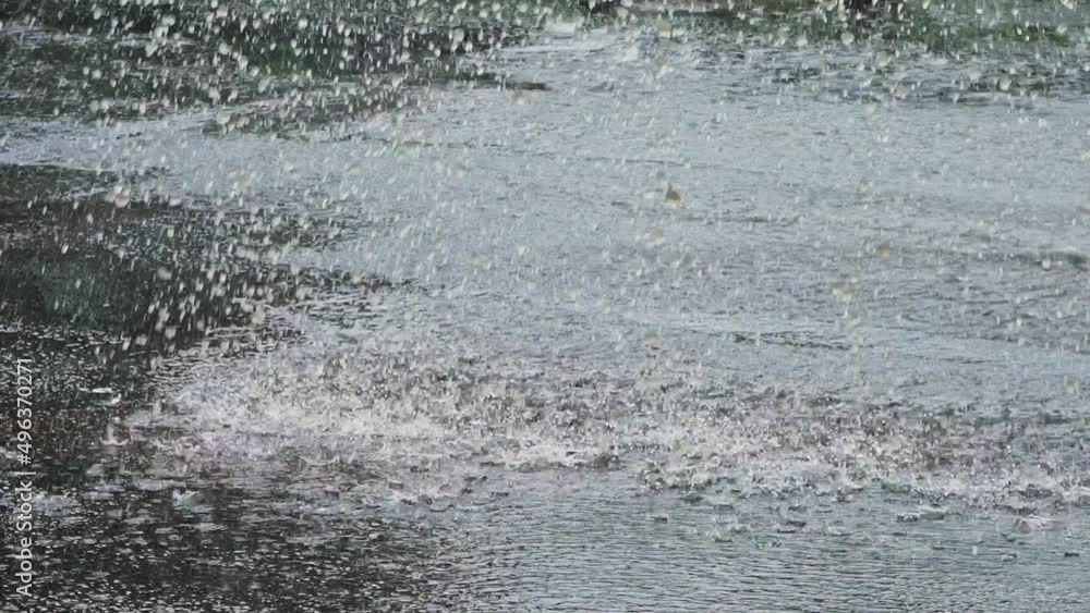 car drives into a puddle of water splashing around. slow motion. the ...