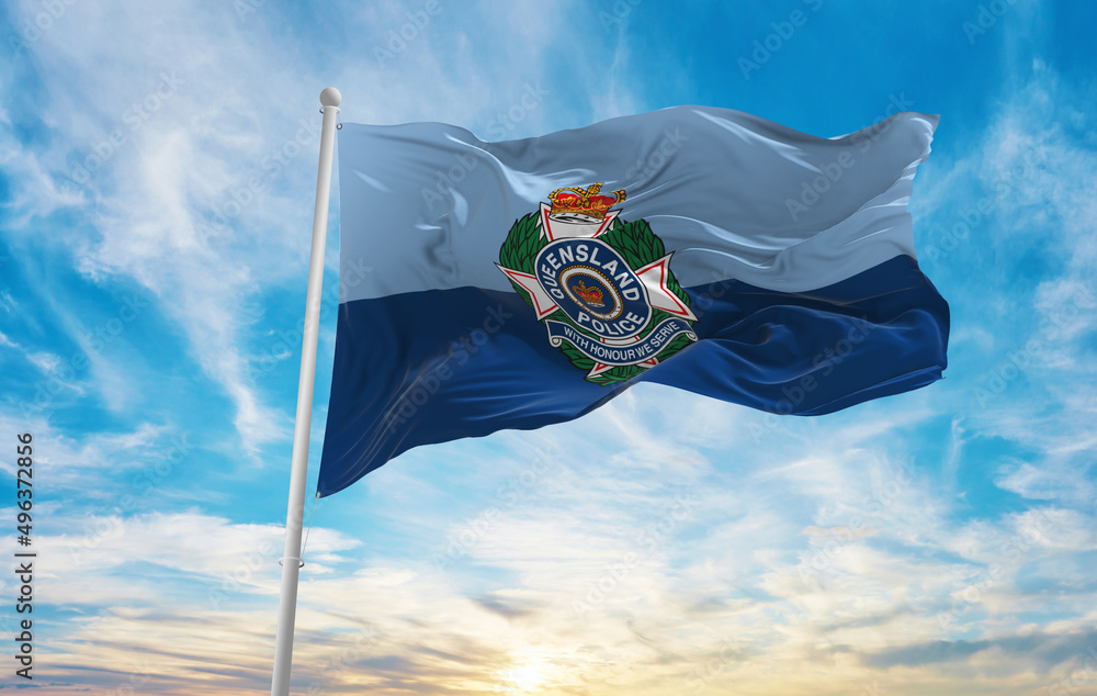 flag of Queensland Police Service , Australia at cloudy sky background ...