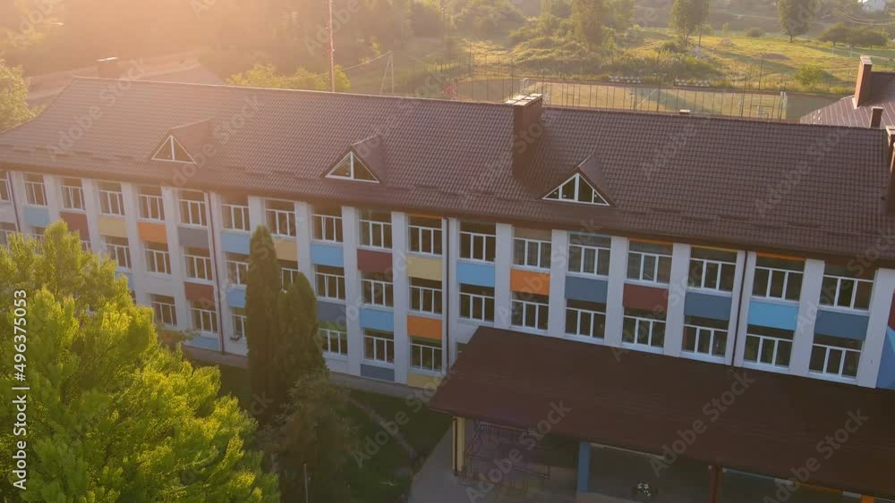 School with green lawn. Public school building. Exterior of the ...