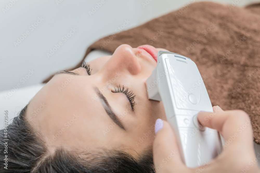 Dermatologist performing a facial analysis and diagnosis on a beautiful ...