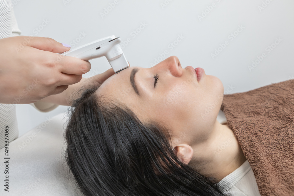 Dermatologist performing a facial analysis and diagnosis on a beautiful ...