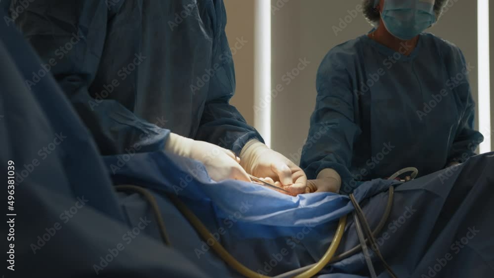 Surgeon ties knots for stitches on open wound. In the Hospital ...