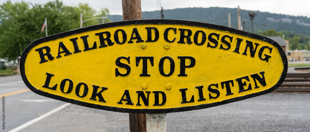 yellow and black painted railroad crossing sign with Stop Look and ...